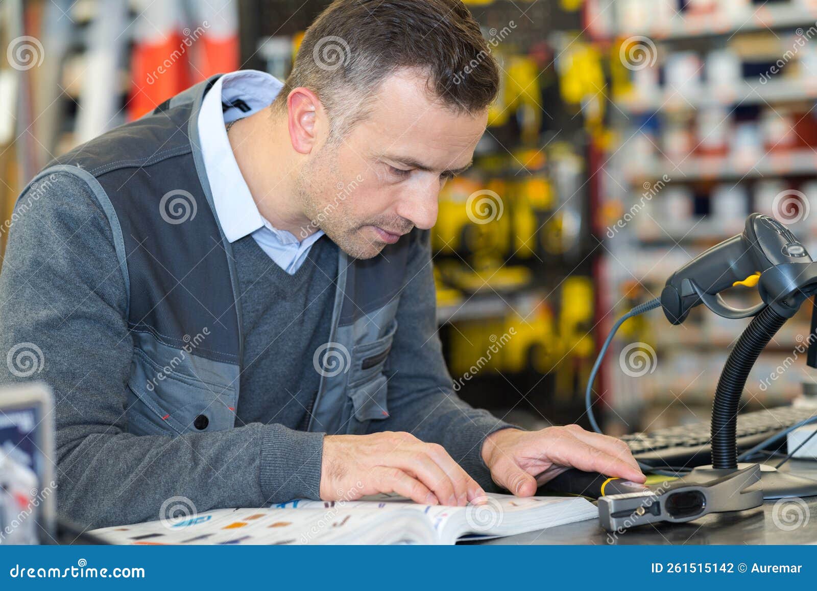 Worker in Hardware Store Looking Up Reference in Catalogue Stock Photo ...