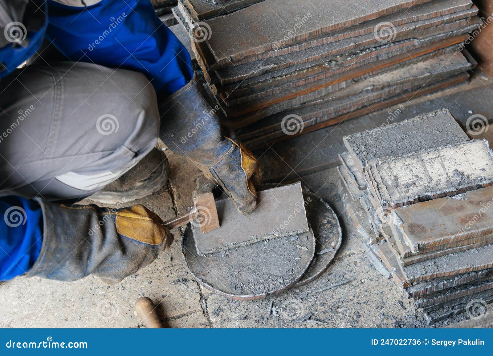 Worker in Heavy Industry or Metallurgy Beats Scale Off Iron Plates with ...