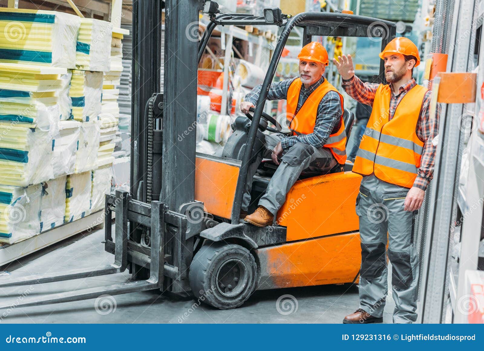 Worker and His Senior Colleague Working with Forklift Machine Stock ...