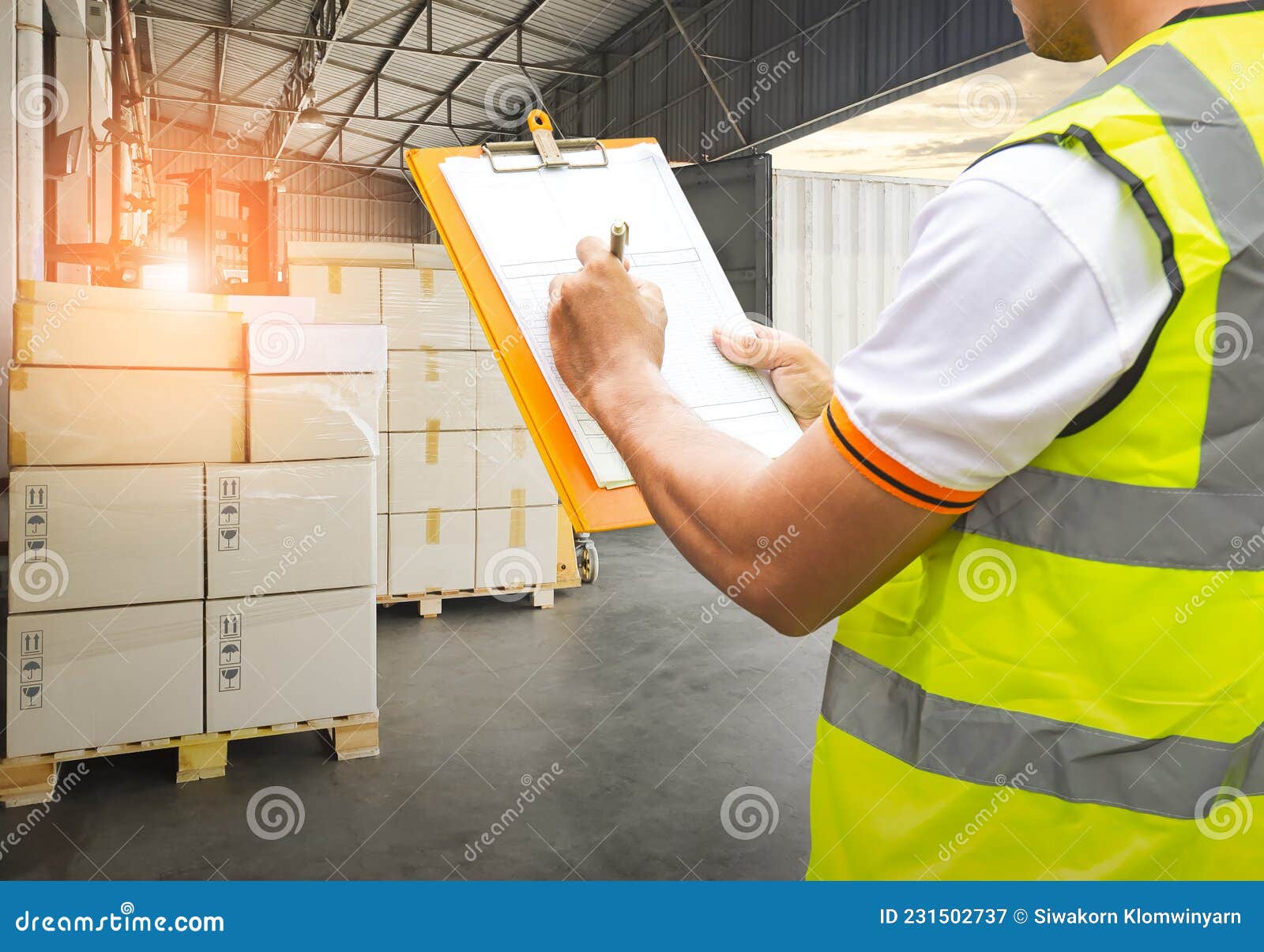 Worker Holding Clipboard is Control Loading Package Box into Cargo ...