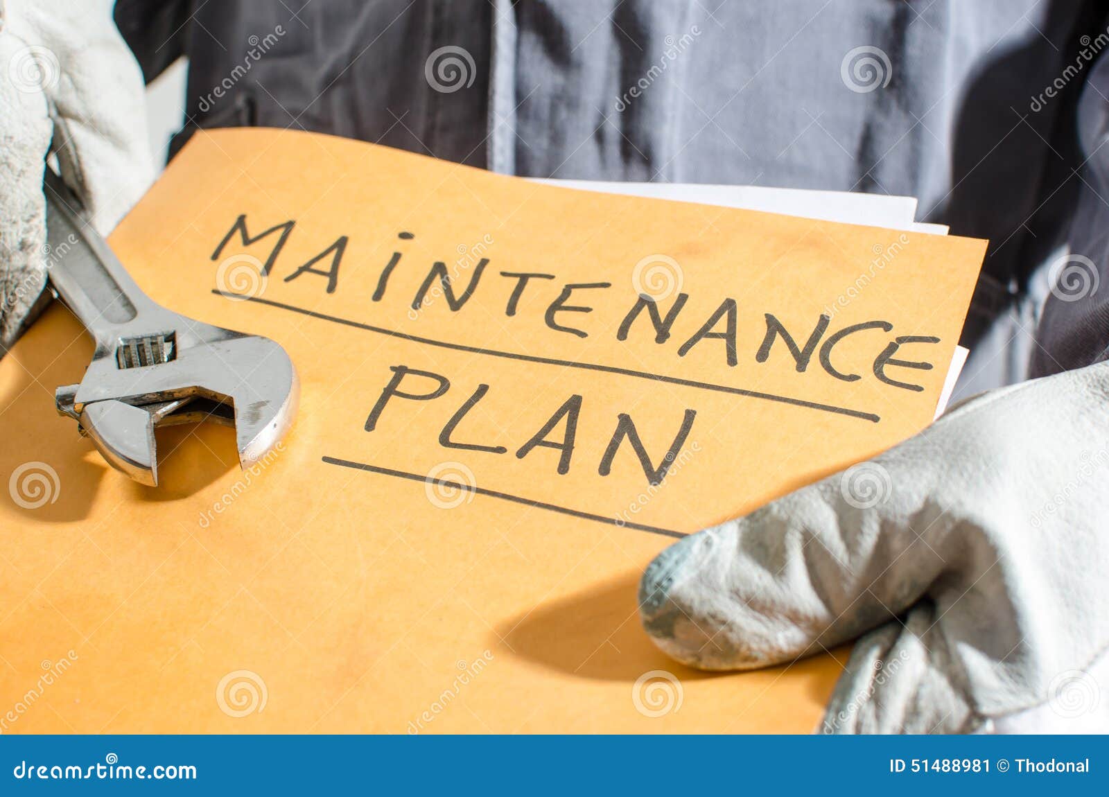 Worker Holding a Folder of Maintenance Plan and Monkey Wrench Stock ...