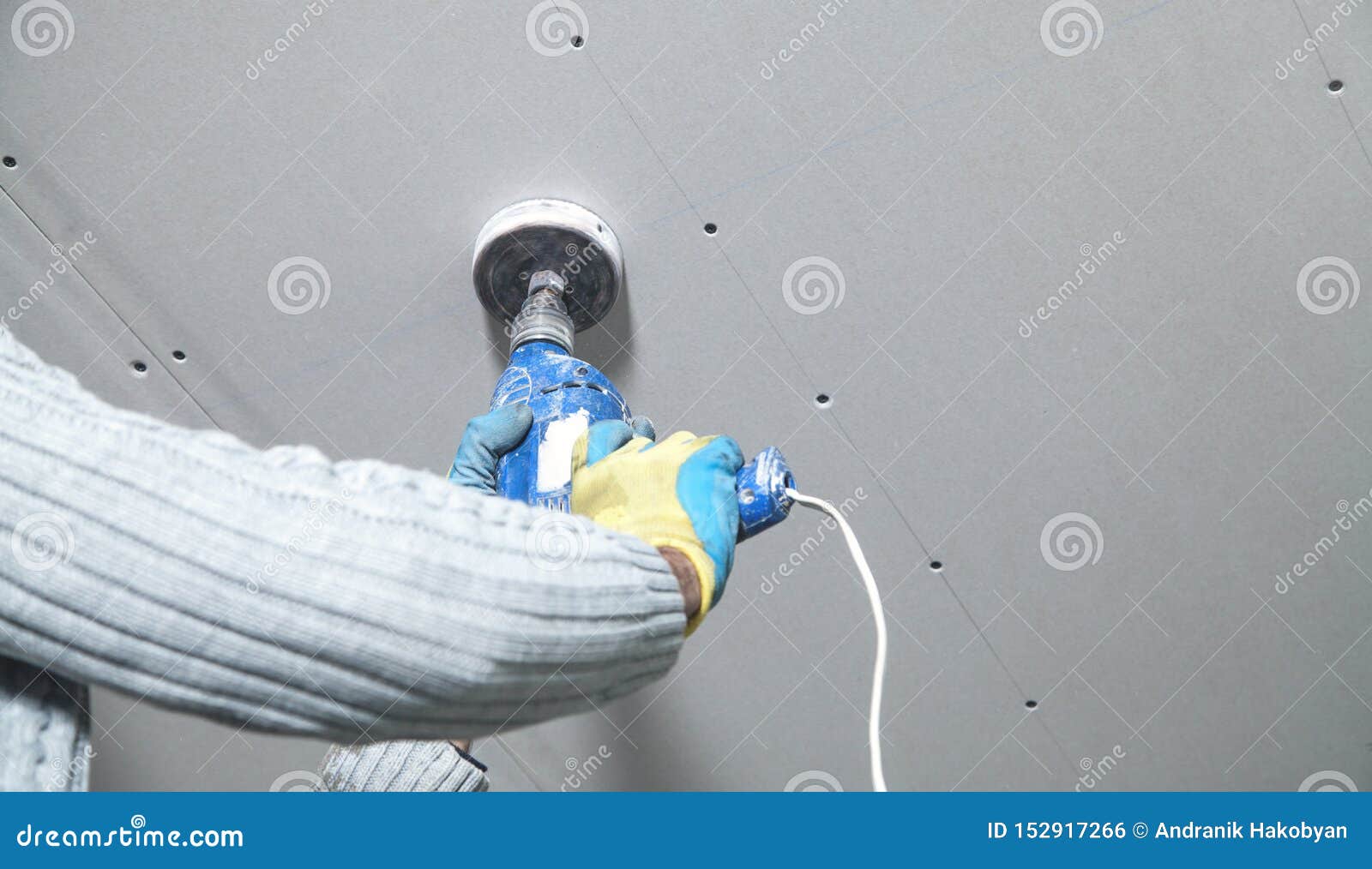 Worker Holding a Power Drill. Make a Hole in the Ceiling Stock Photo ...