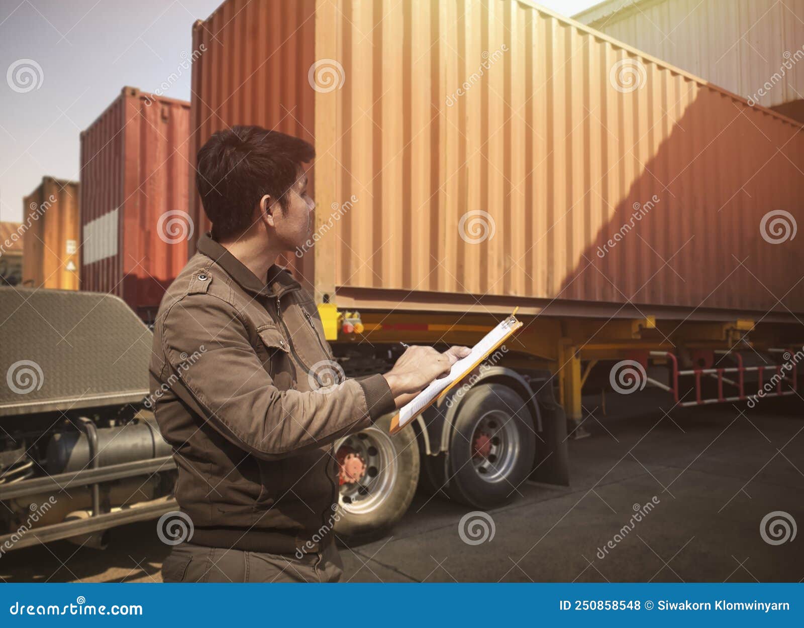 Worker Holds a Clipboard Controlling the Loading of Cargo into Shipping ...