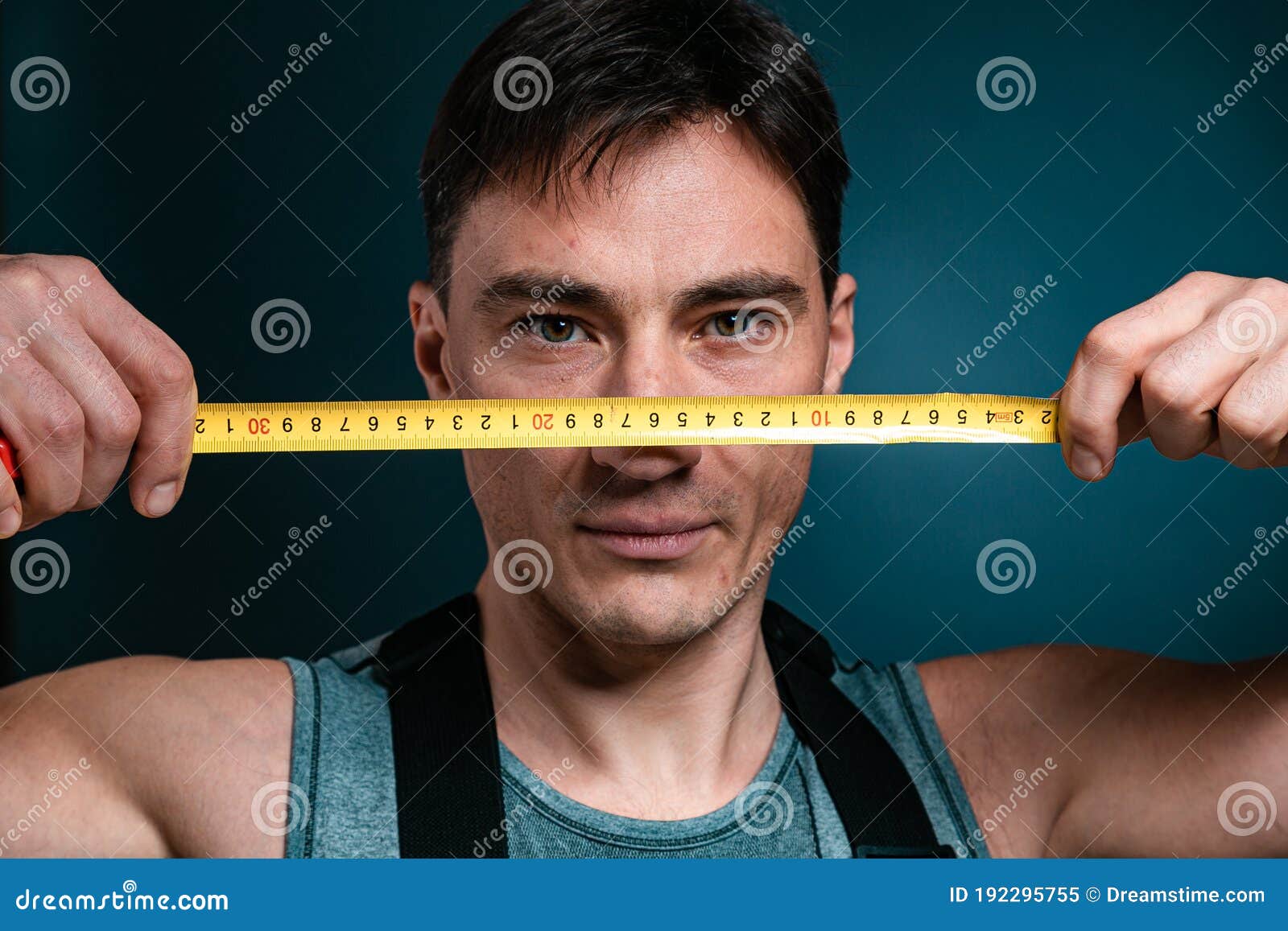 A Worker Holds a Tape Measure in Front of His Face Stock Image - Image ...