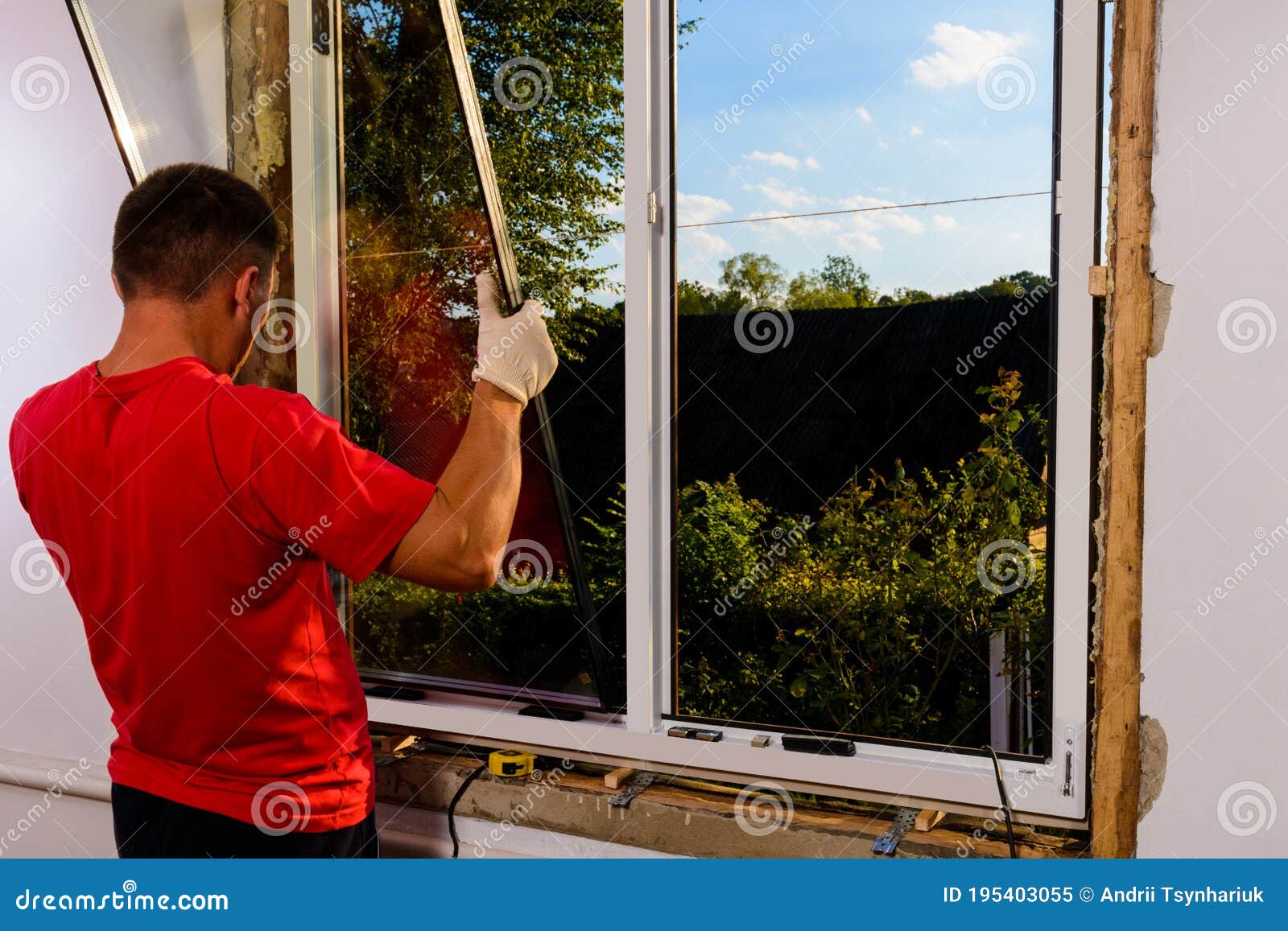 The Worker Inserts Glass into the Window Frame, Triple Glazing of the ...