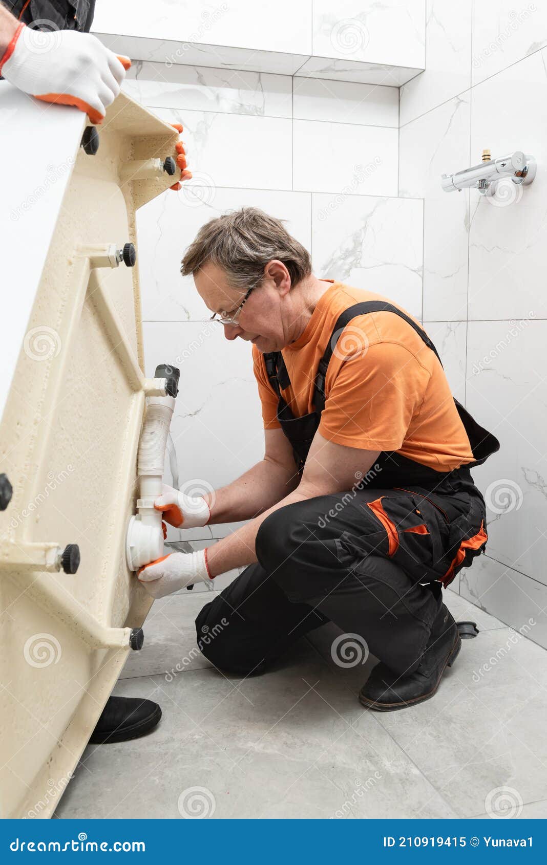 The Worker is Installing a Siphon on a Shower Tray in the Bathroom ...