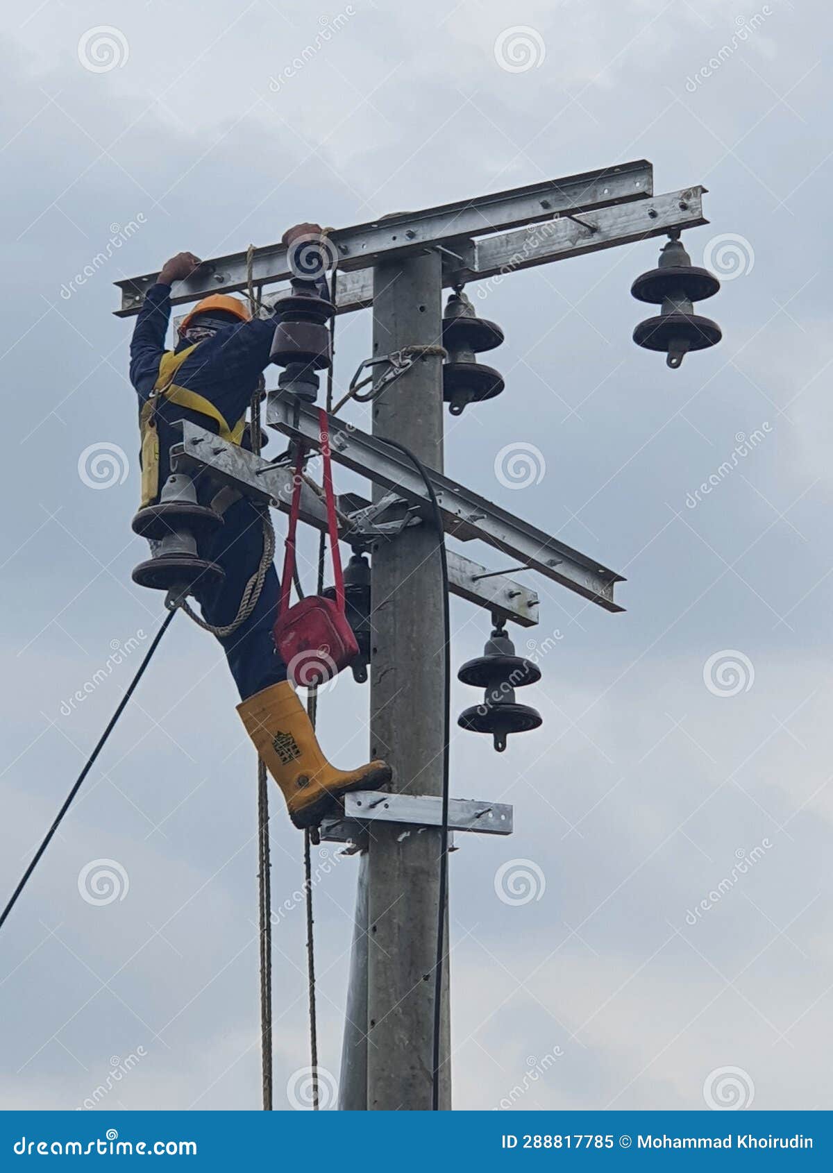 A Worker is Installing an Electric Cable on a Power Pole Stock Image ...