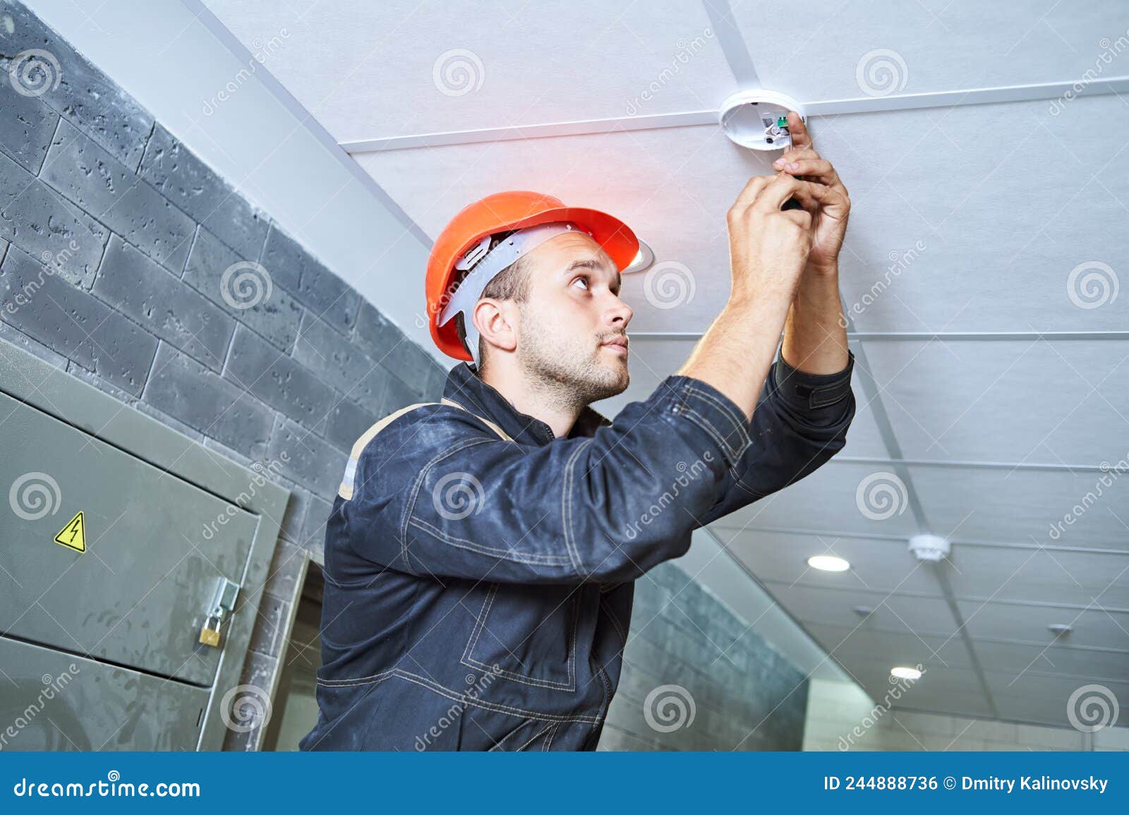 Worker Installing Smoke Detector on the Ceiling. Fire Alarm System ...