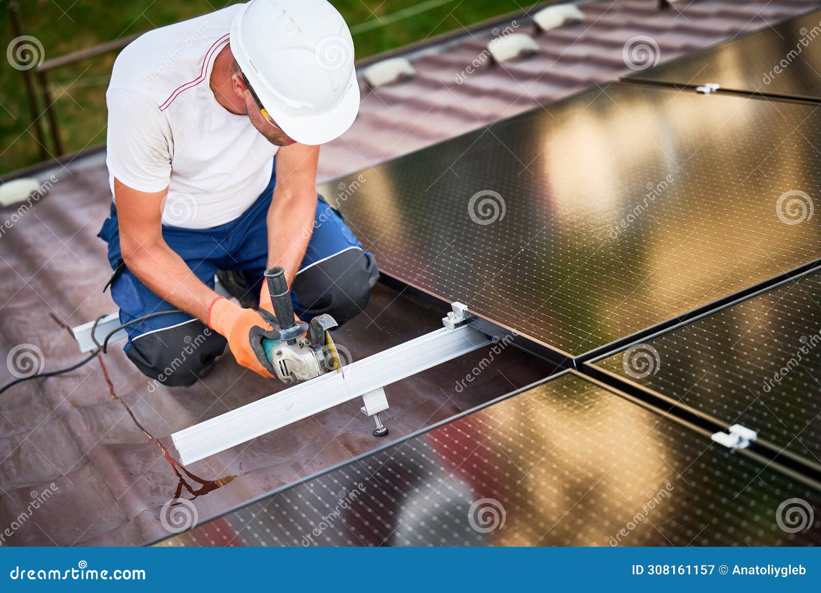 Worker Installing Solar Panel System on Roof Using Grinder on Metal ...