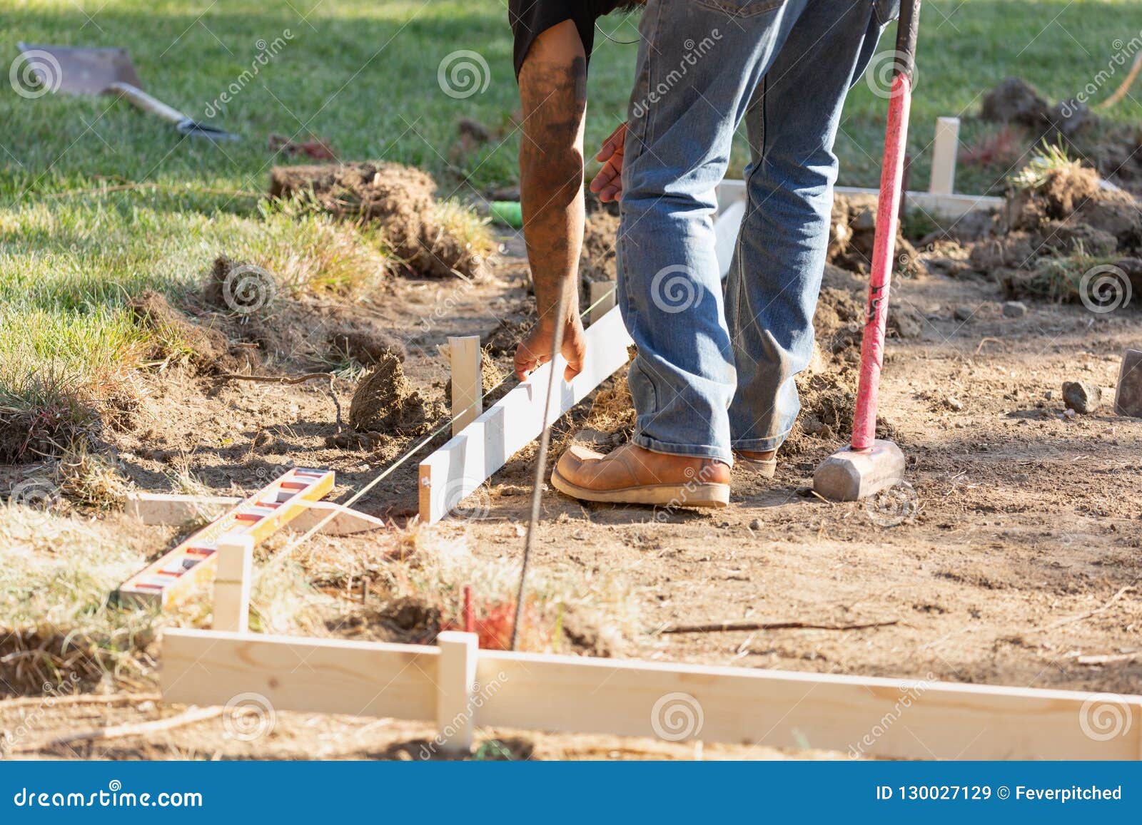 Worker Installing Stakes and Lumber Guides at Construction Site Stock ...