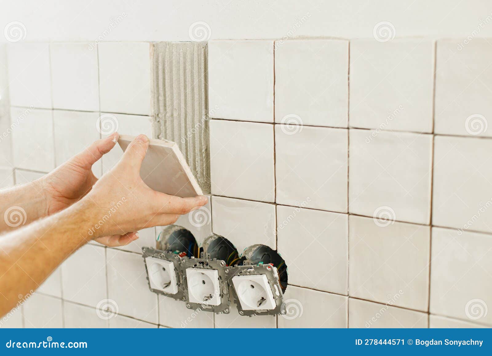 Worker Installing Stylish White Tiles on Wall at Electricity Socket ...