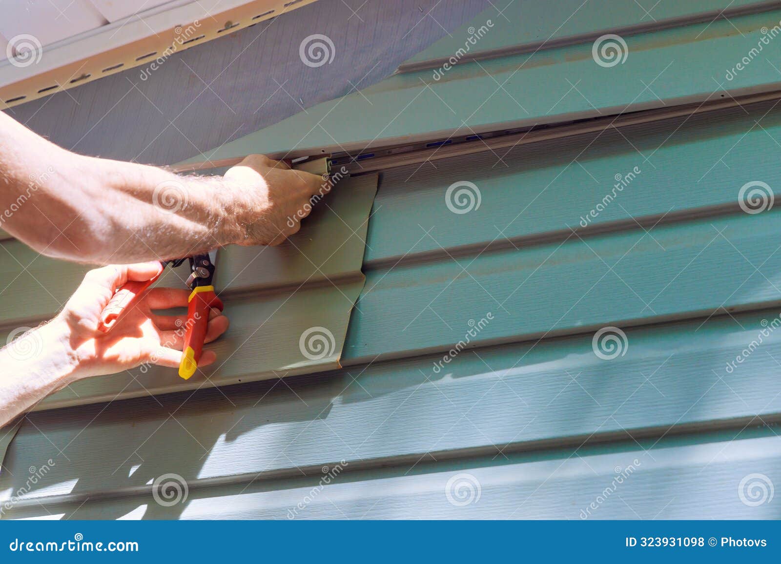 Worker Installing Vinyl Plastic Siding Panels on Wall Facade of a New ...
