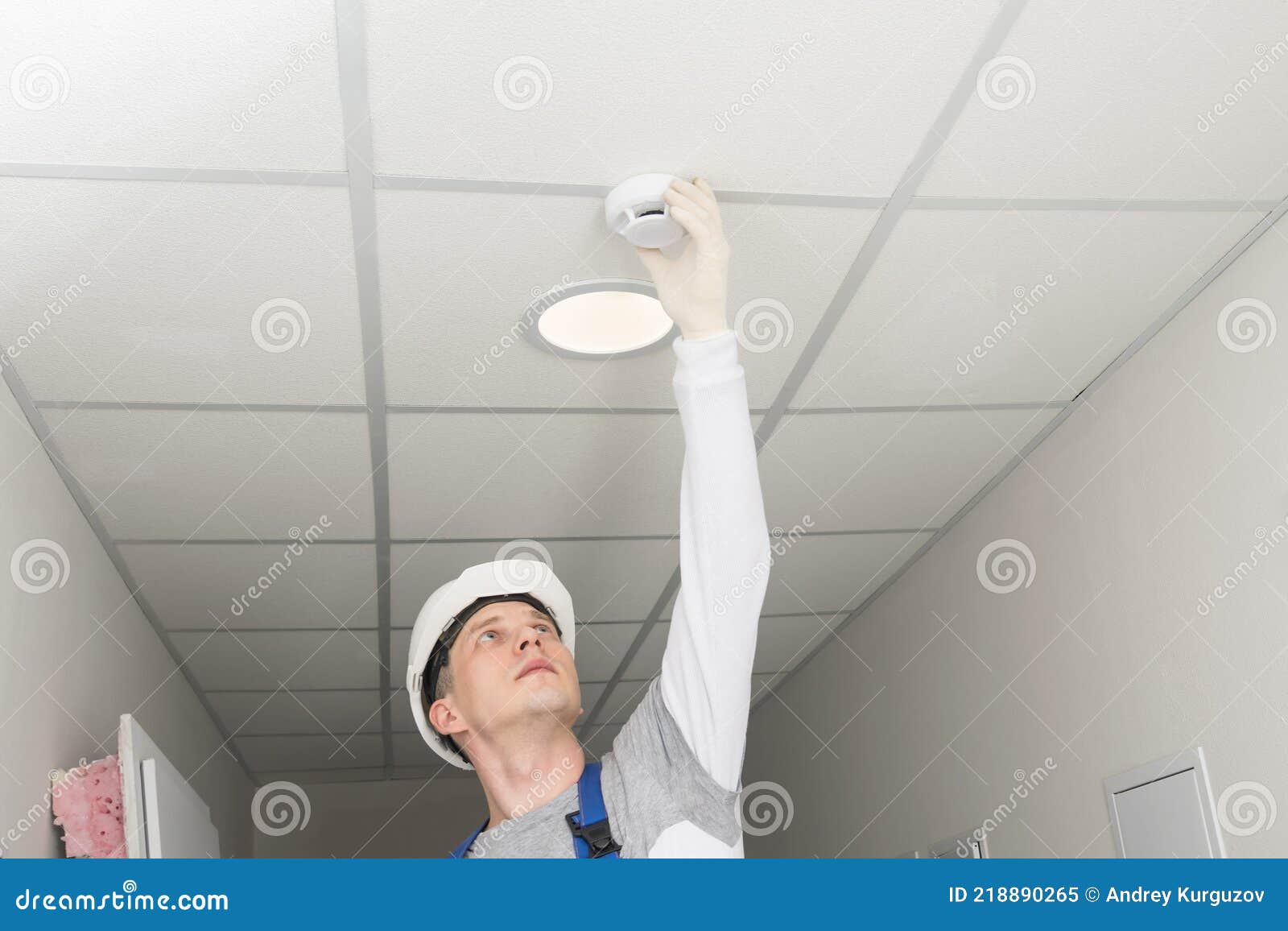 A Worker Installs a Fire Safety Sensor on a Suspended Ceiling Stock ...