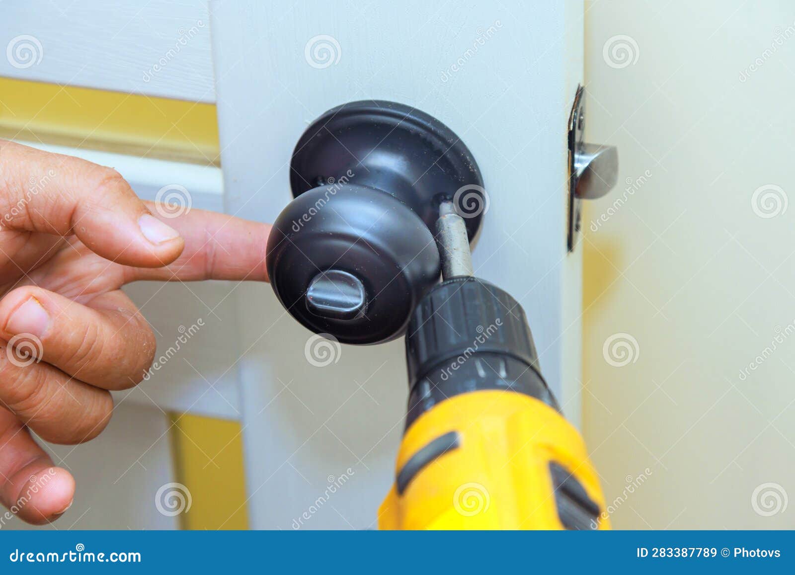 Worker Installs a Lock in a New Interior Door with Using Screwdriver ...