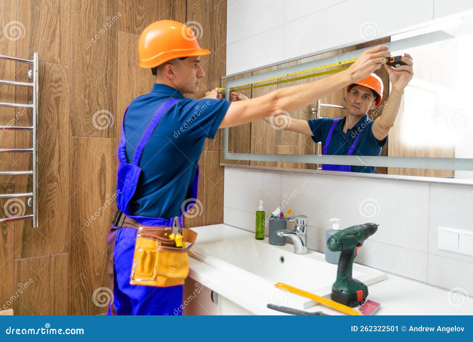 The Worker Installs the Mirror in the Bathroom Stock Image - Image of ...