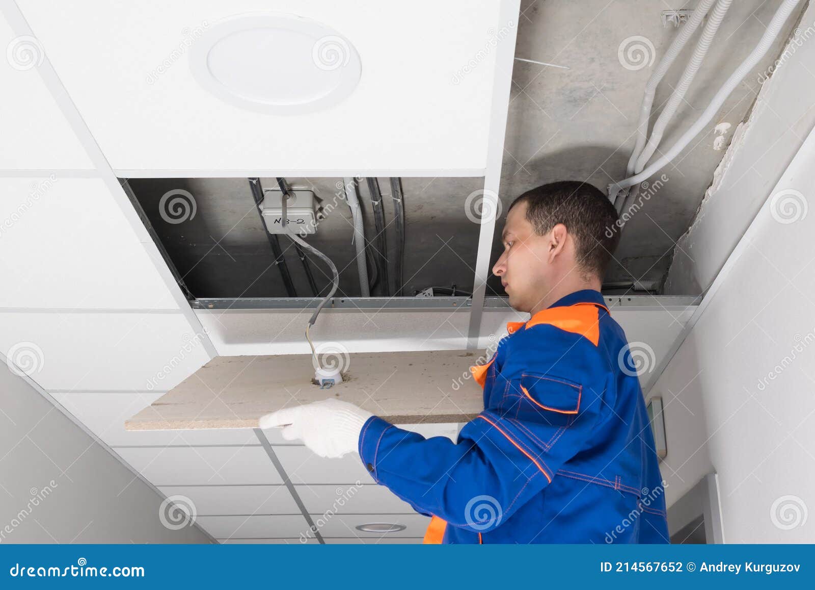 A Worker Installs a Motion Sensor in the False Ceiling Stock Photo ...