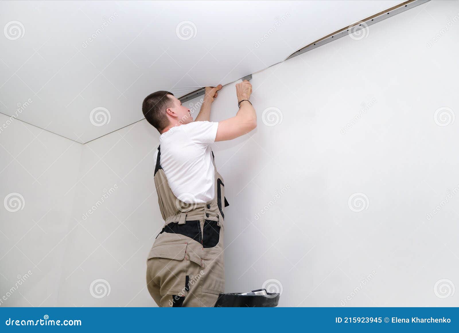 Worker Installs a Stretch Ceiling. Construction and Renovation Stock ...