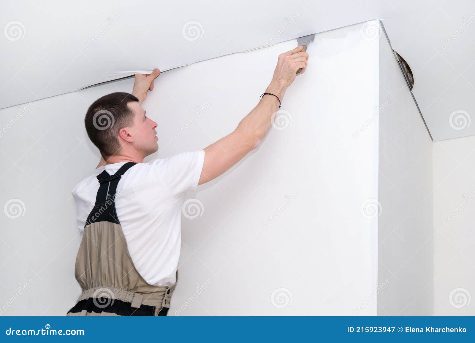 Worker Installs a Stretch Ceiling. Construction and Renovation Stock ...
