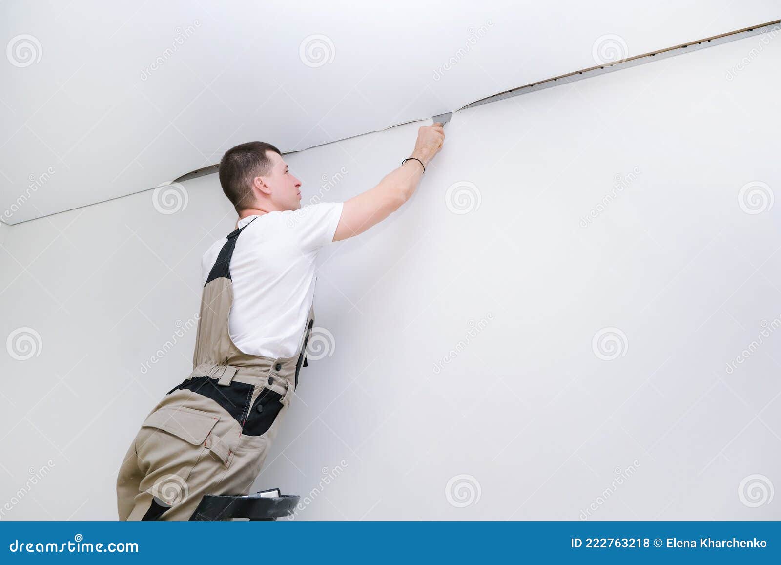 Worker Installs a Stretch Ceiling. Construction and Renovation Stock ...