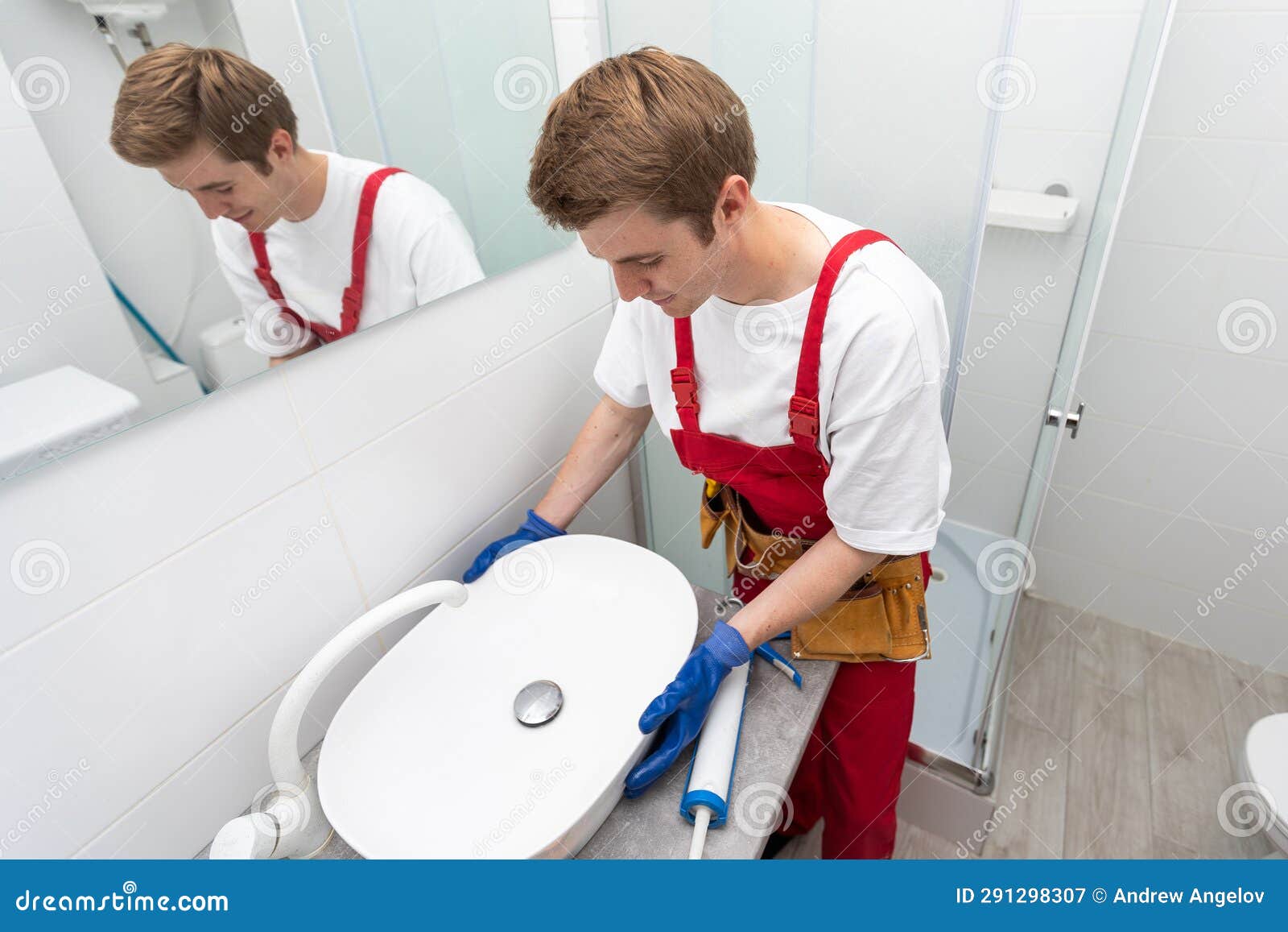 A Worker Installs a Wash Basin in a Bathroom. Stock Image - Image of ...