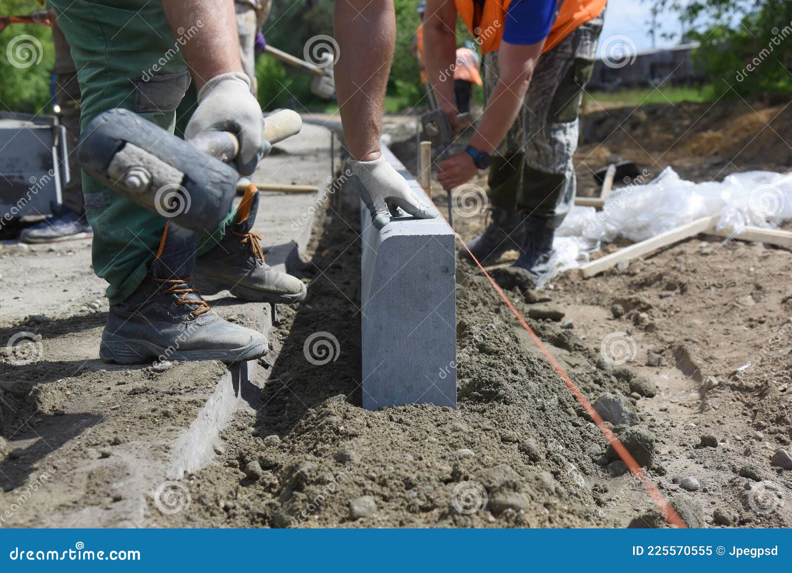 A Worker Knocks with a Hammer Aligns a Concrete Curb. Stock Image ... A Worker Knocks with a Hammer Aligns a Concrete Curb. Stock Image ...