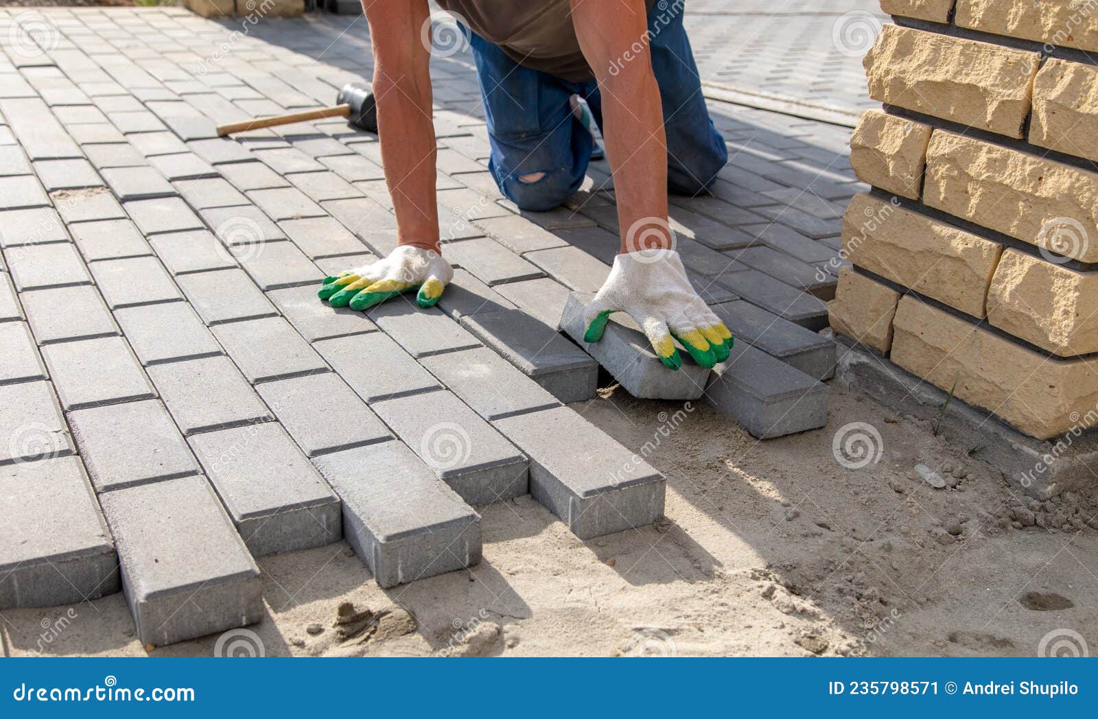 A Worker is Laying Paving Slabs in the Yard. Construction Stock Image ...