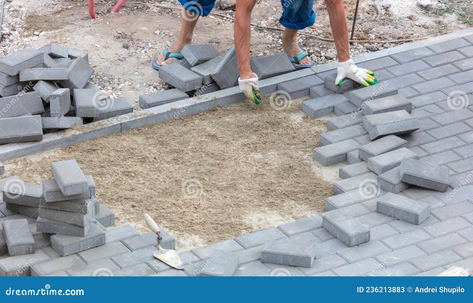 A Worker is Laying Paving Slabs in the Yard. Construction Stock Image ...