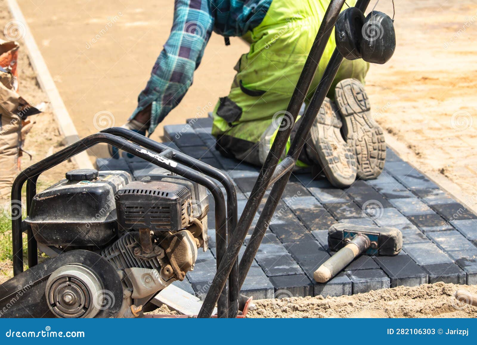 A Worker Laying Paving Stones at a Sidewalk Construction Site, Close Up ...