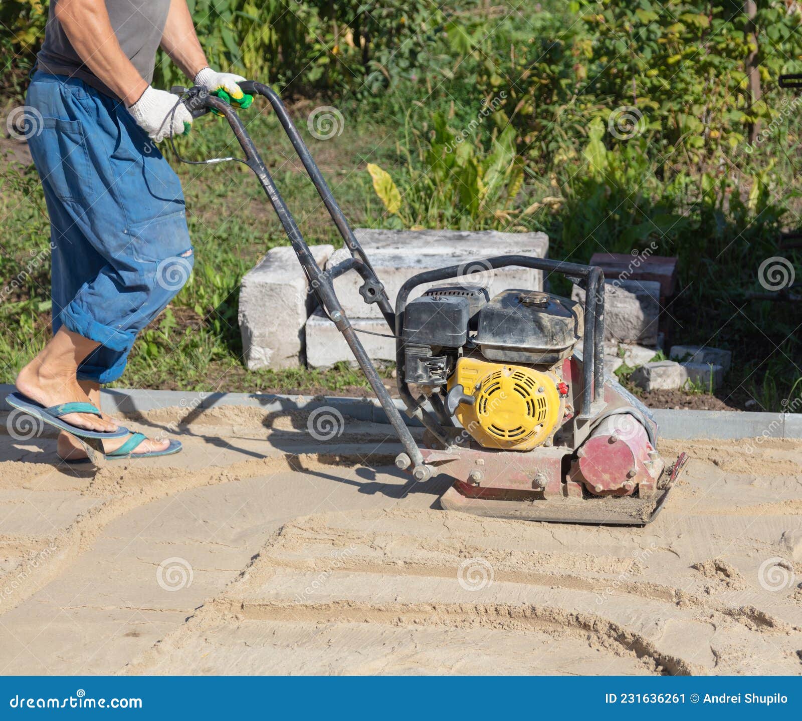 A Worker Lays Down Gravel and Sand for Paving Slabs. Stock Image ...