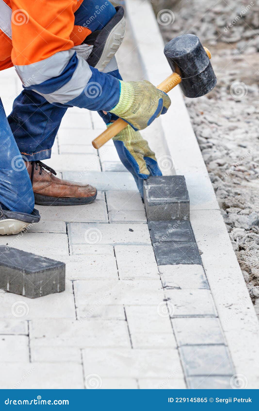 A Worker Lays Down Paving Slabs with a Rubber Hammer on a Pedestrian ...