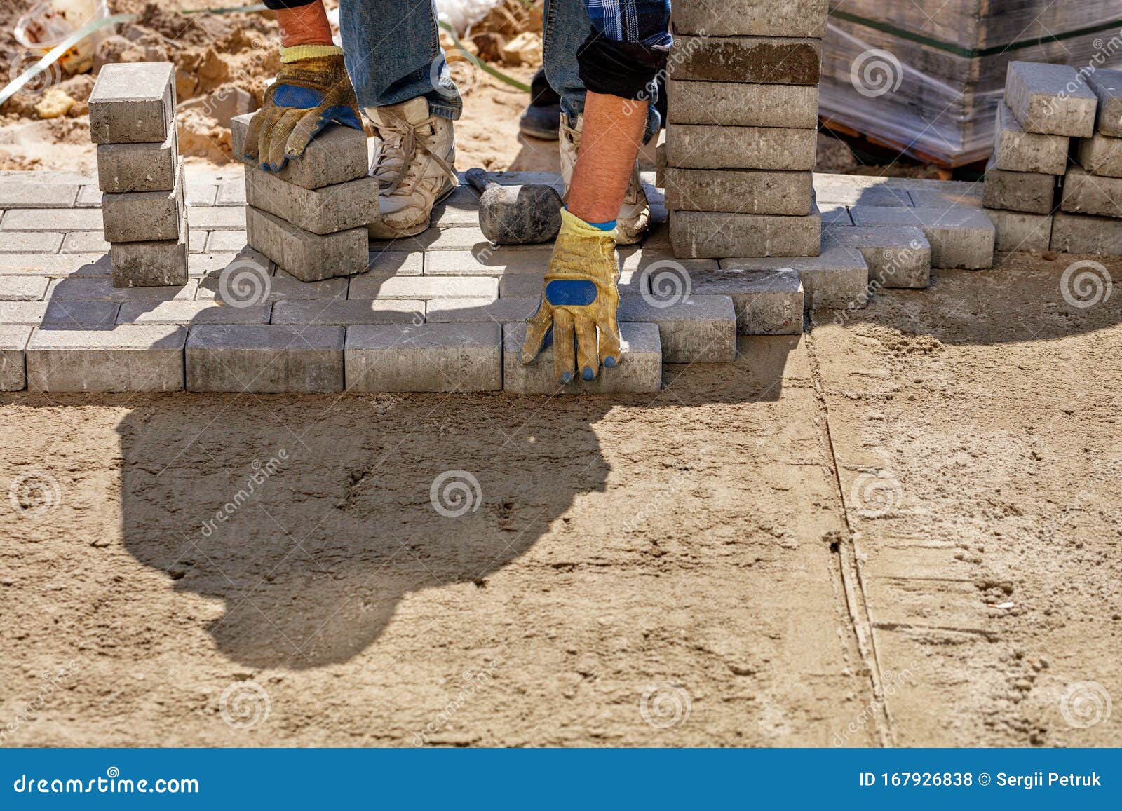 A Worker Lays Paving Slabs on a Prepared Flat Sandy Platform on the ...