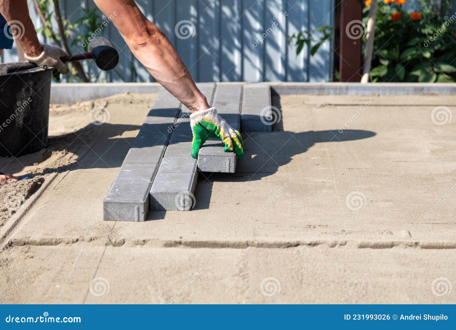 A worker lays paving slabs stock photo. Image of worker - 231993026