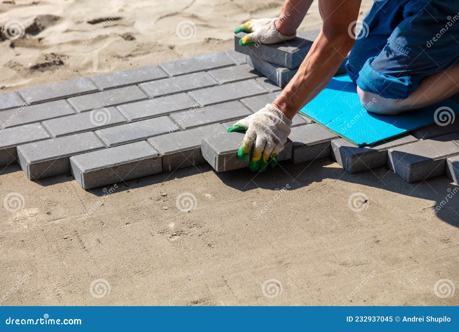 A worker lays paving slabs stock image. Image of cement - 232937045