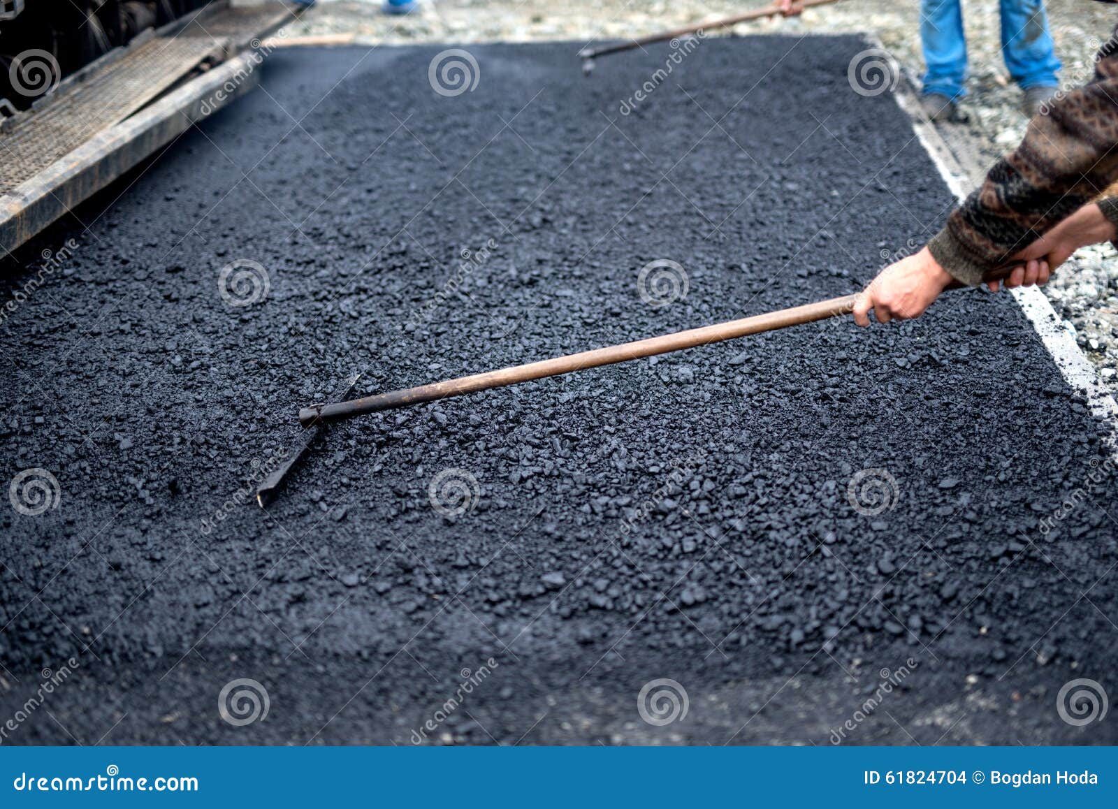 Worker Leveling Fresh Asphalt on a Road Construction Site, Industrial ...