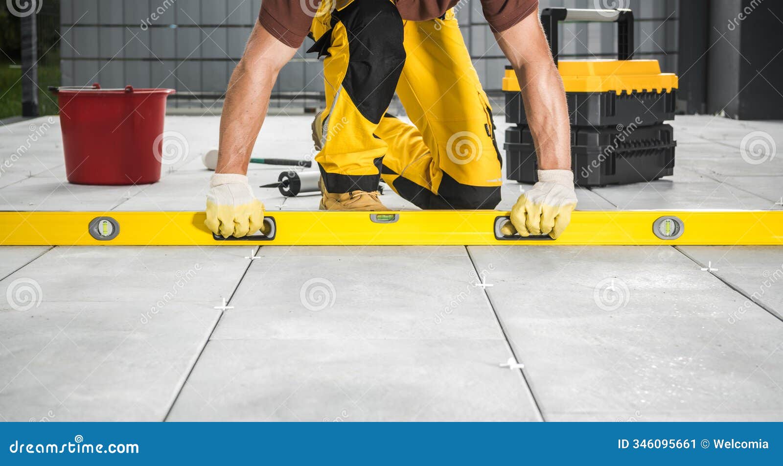 Worker Leveling Tiles on a Construction Site during Daytime with Focus ...