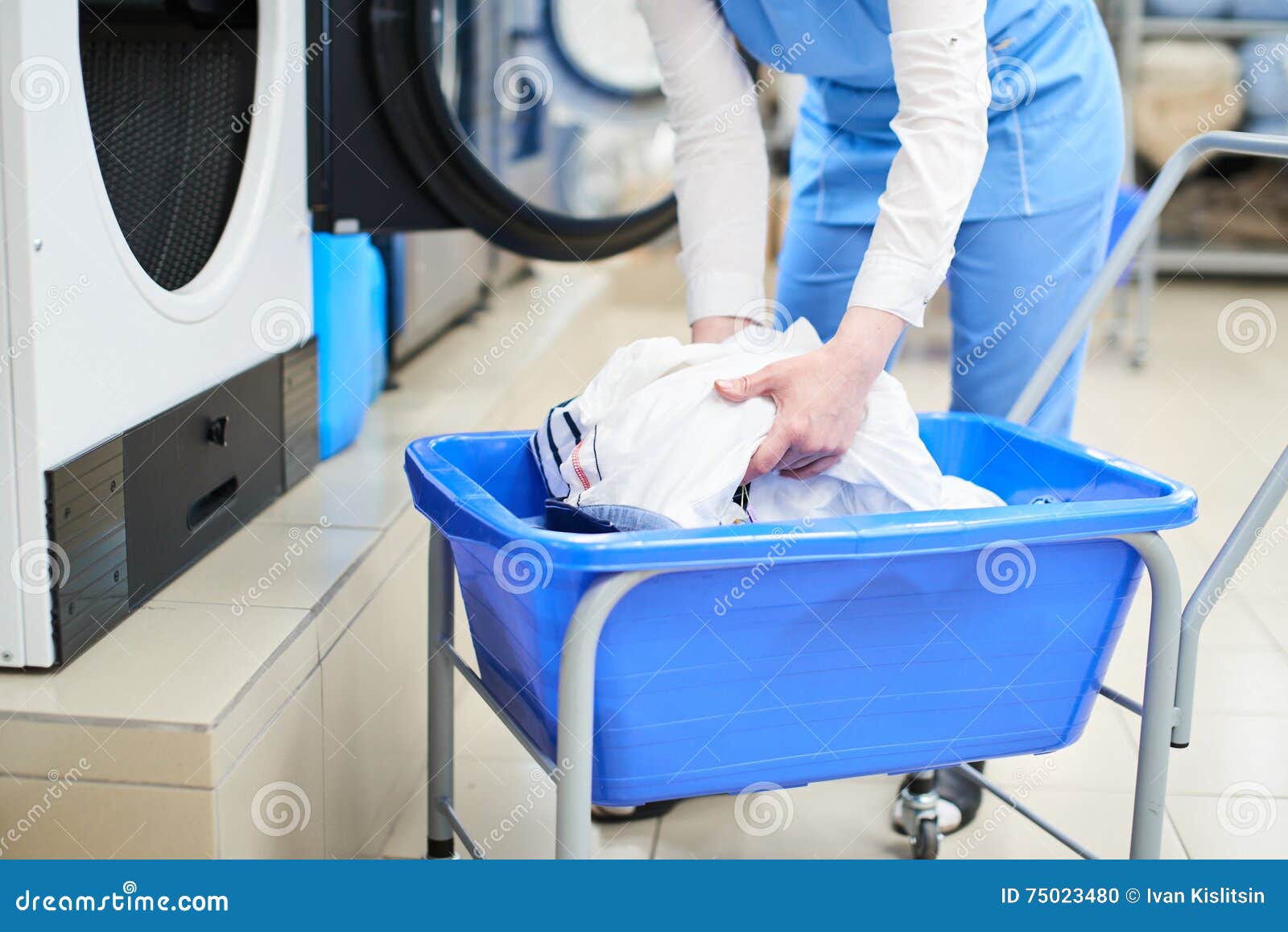 The Worker Loads the Laundry Clothing into the Washing Machine Stock ...