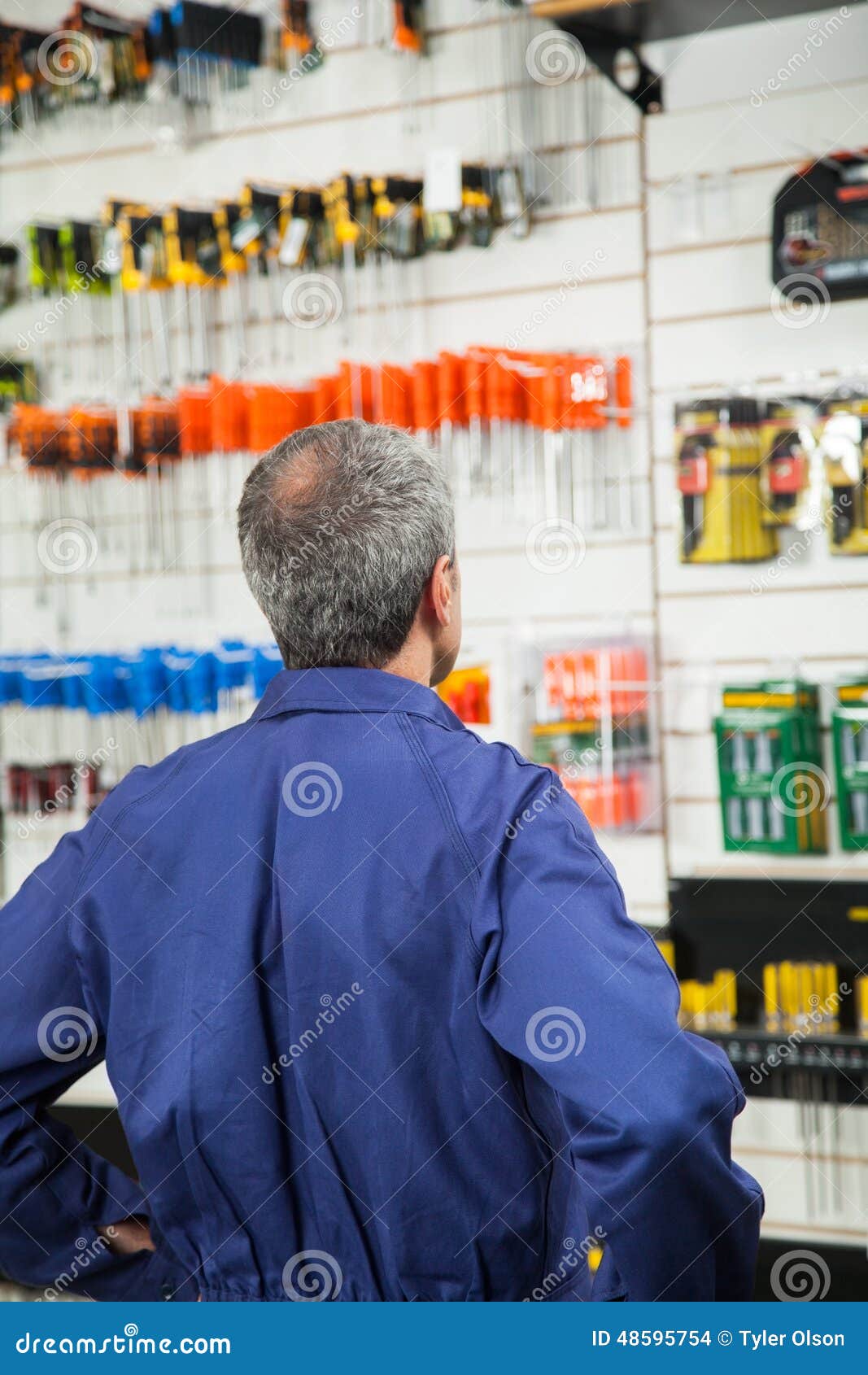 Worker Looking at Tools in Hardware Store Stock Photo - Image of blue ...