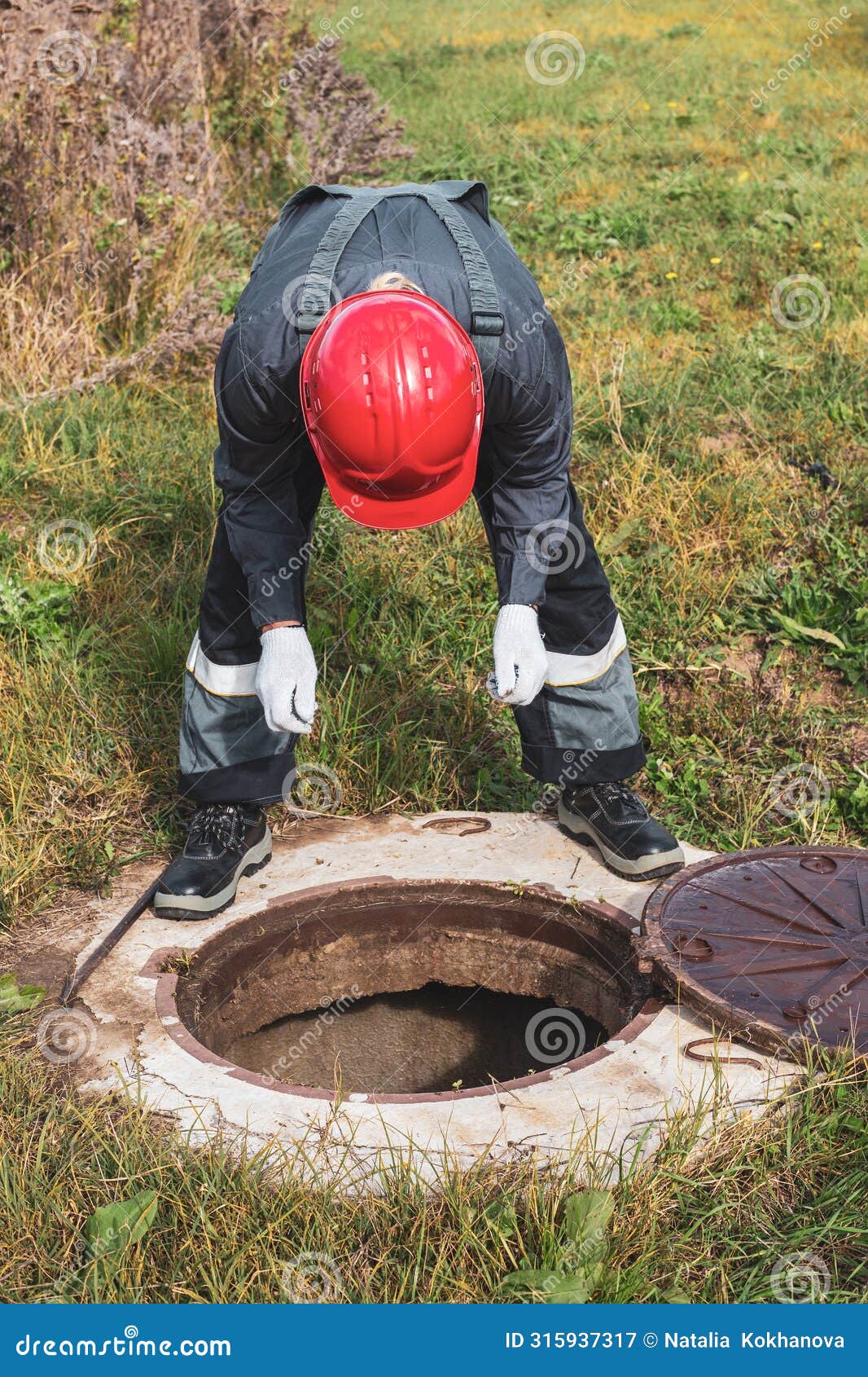 A Worker Looks into a Septic Sewer Well, Checking for Water ...