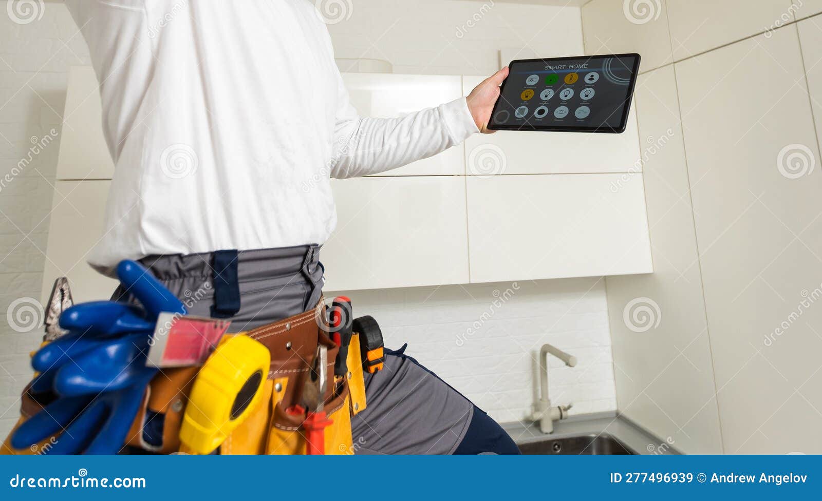 A Worker Looks at a Tablet Computer. Master with an Electronic Tablet ...