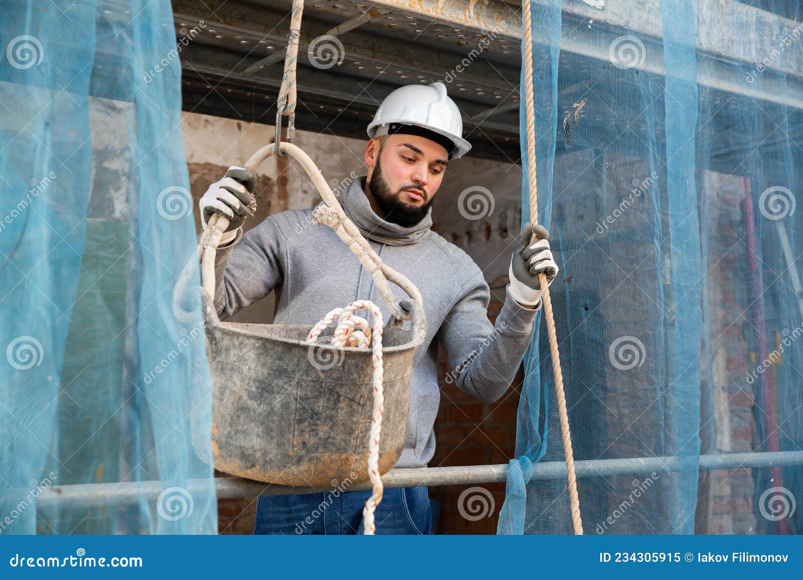 Worker Lowering Down Bucket with Construction Mortar Stock Image ...