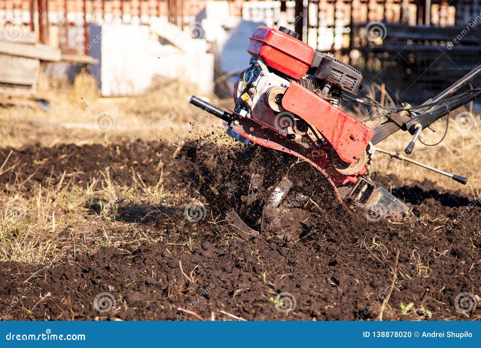 Worker with a Machine Cultivator Digs the Soil in the Garden Stock ...