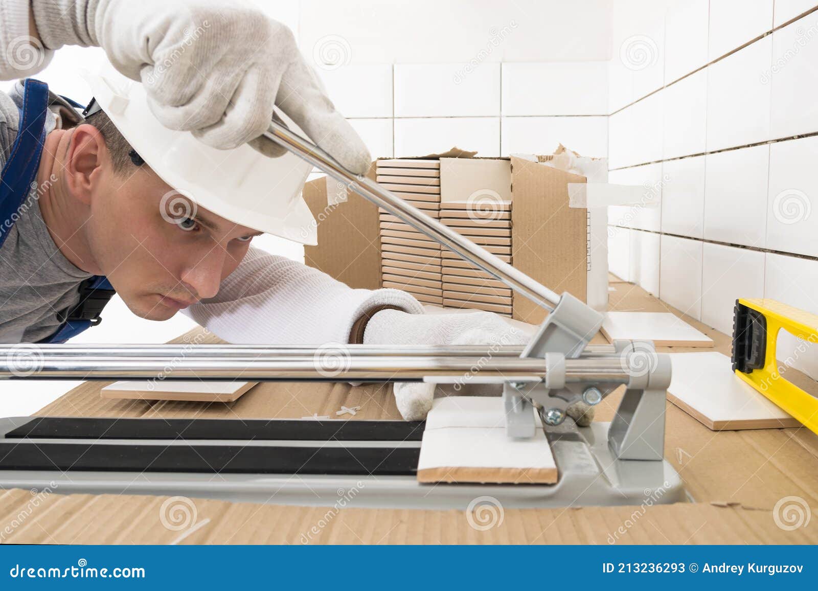 A Worker Makes a Cut of a Ceramic Tile with a Special Tool, Side View ...