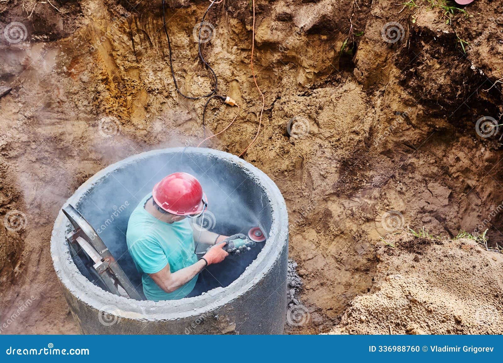 Worker Makes Hole for an Inlet Pipe in Concrete Septic Tank Ring Using ...