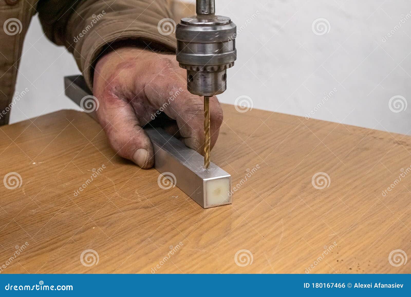 A Worker Makes a Hole in a Rectangular Aluminum Pipe Using a Drilling ...