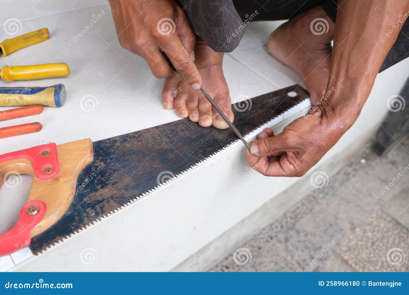 A Worker Man Pose Doing Sharpening of His Old Rusty Saw Tooth in Manual ...