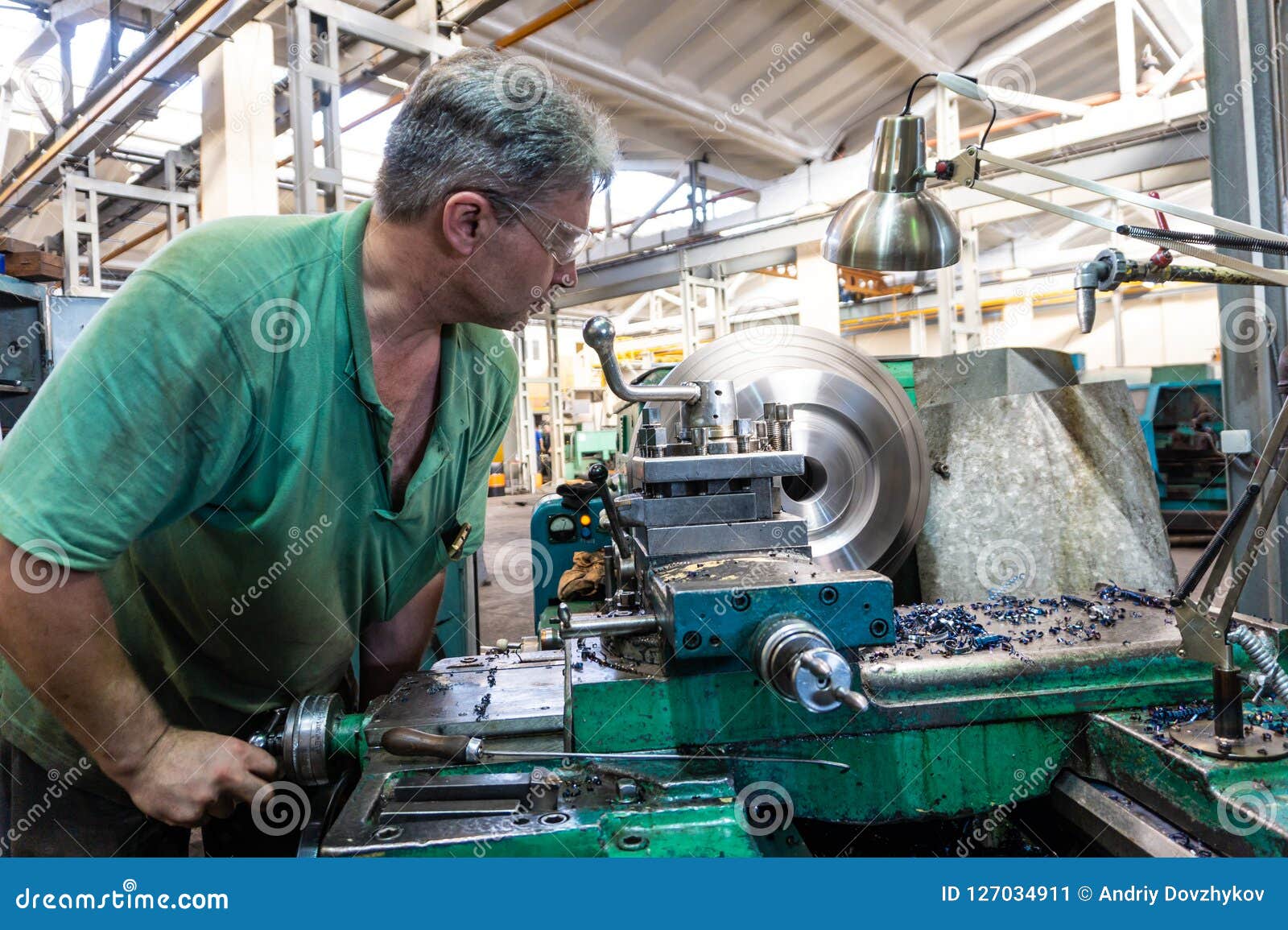 Worker, a Man Processes Metal Products on a Machine. Turning Work in ...