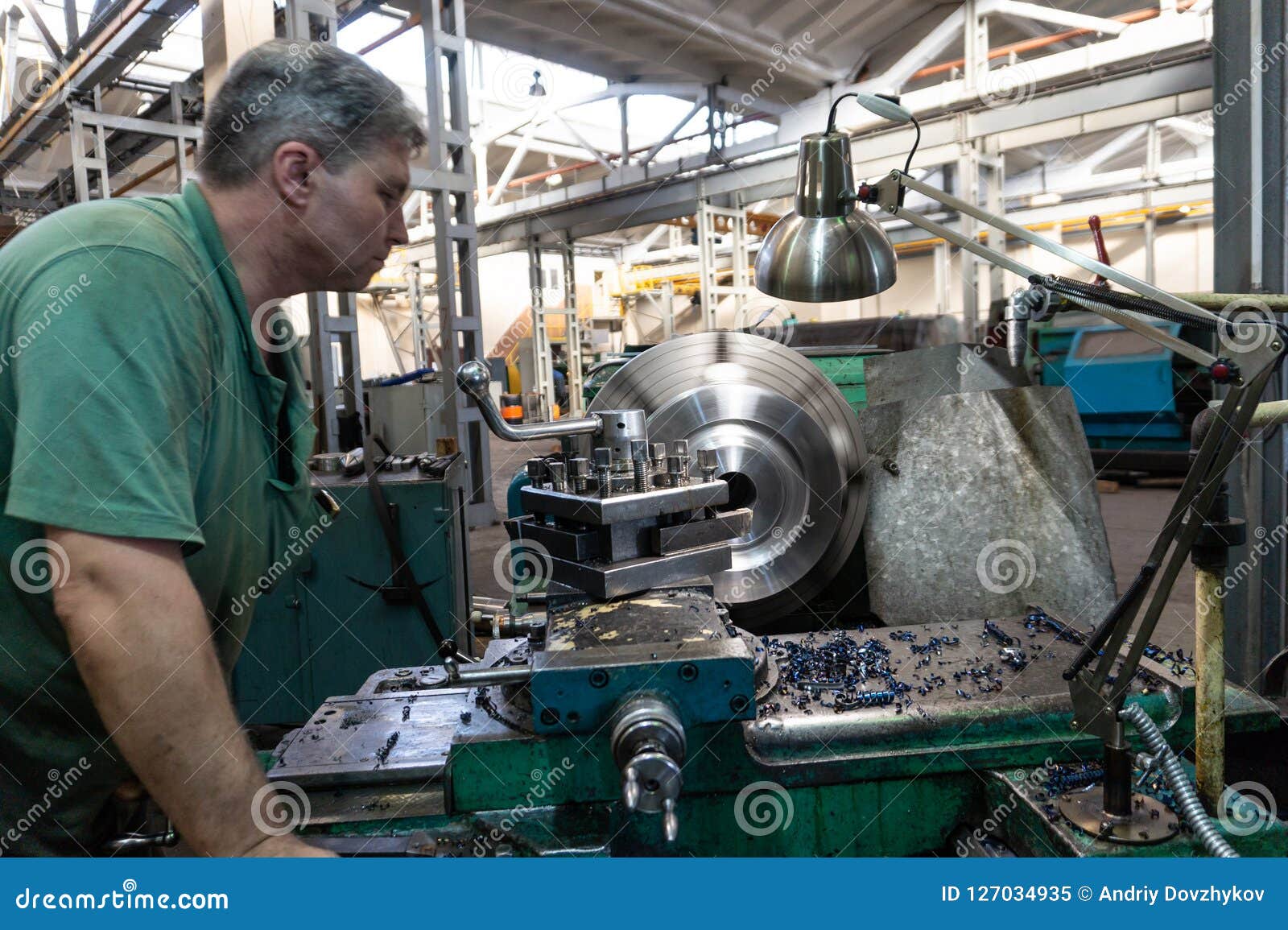 Worker, a Man Processes Metal Products on a Machine. Turning Work in ...