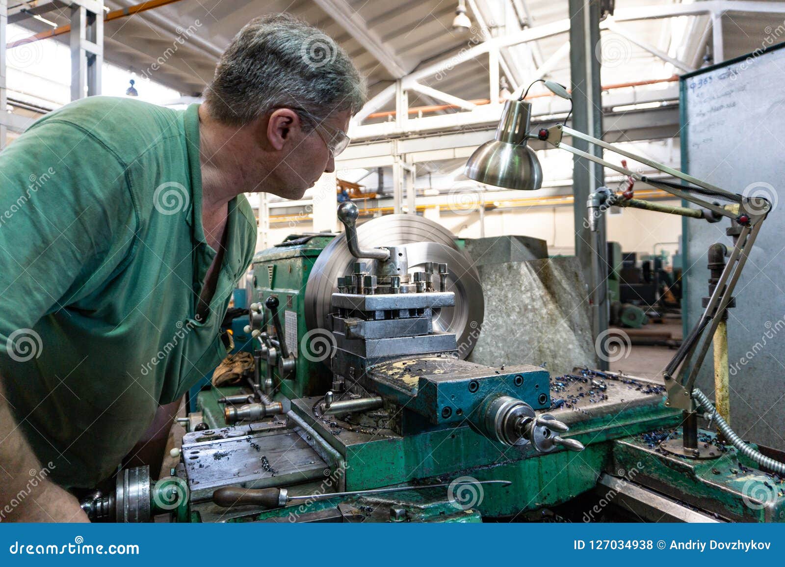 Worker, a Man Processes Metal Products on a Machine. Turning Work in ...