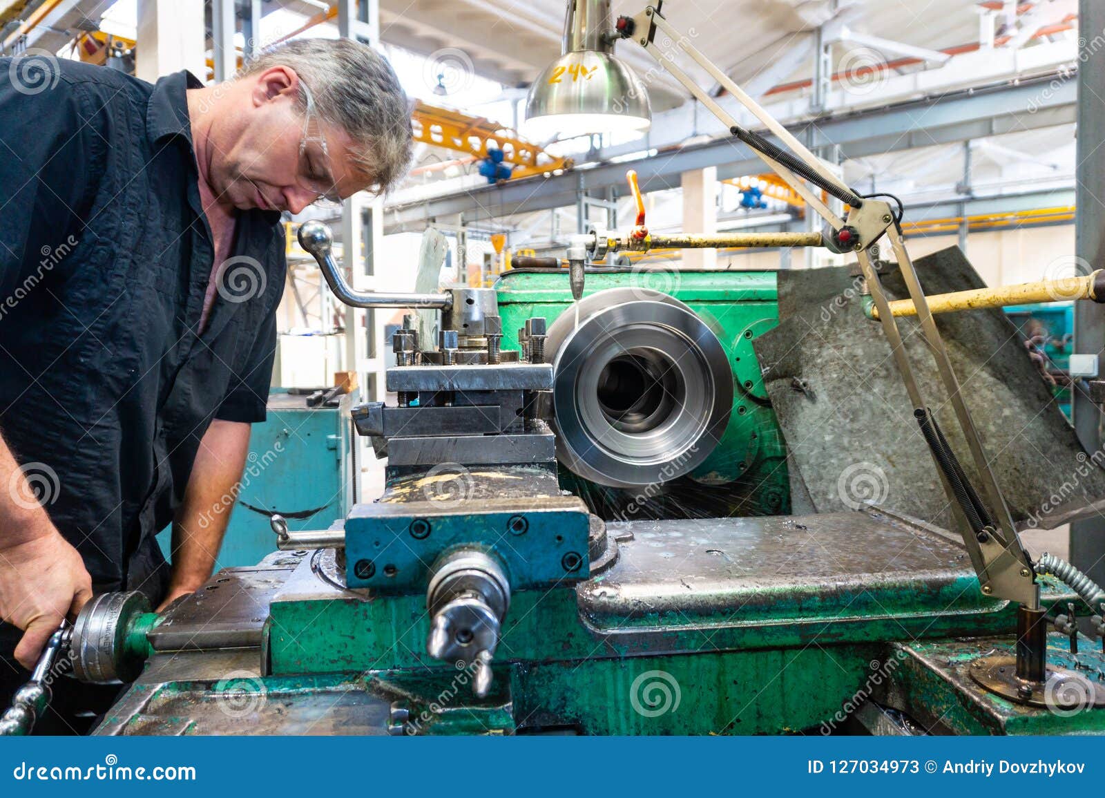 Worker, a Man Processes Metal Products on a Machine. Turning Work in ...