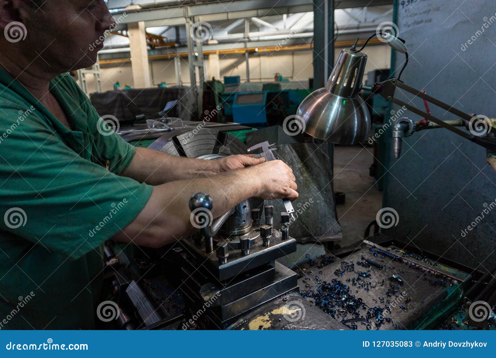 Worker, a Man Processes Metal Products on a Machine. Turning Work in ...